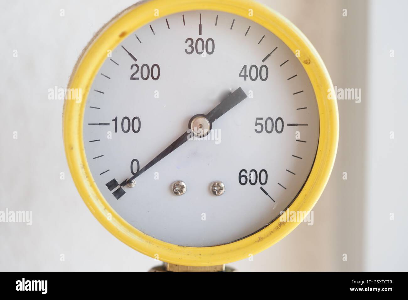 Pressure gauge with yellow casing displaying measurement values Stock ...