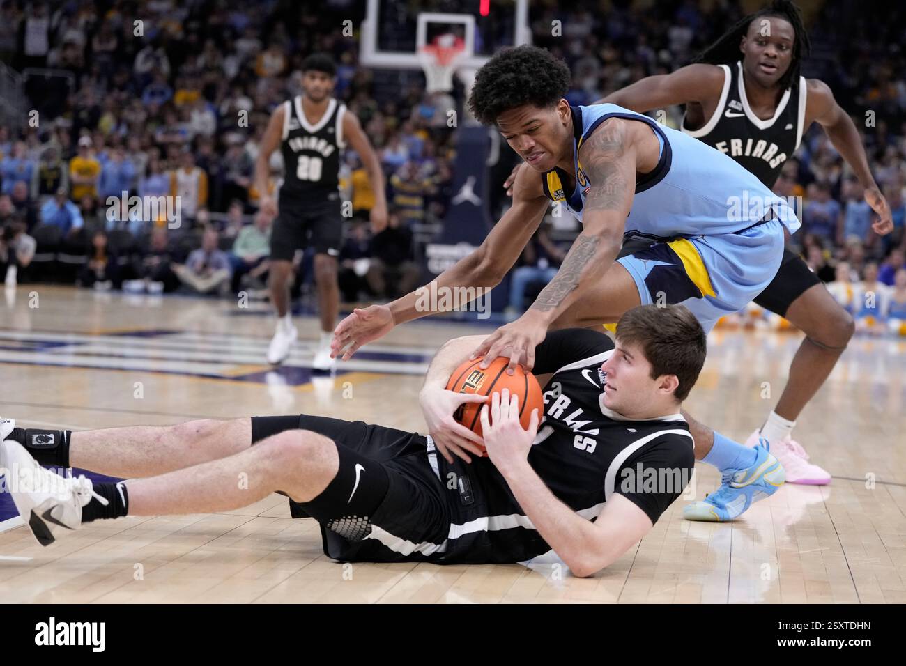 Providence's Ryan Mela and Marquette's Damarius Owens go after a loose ...