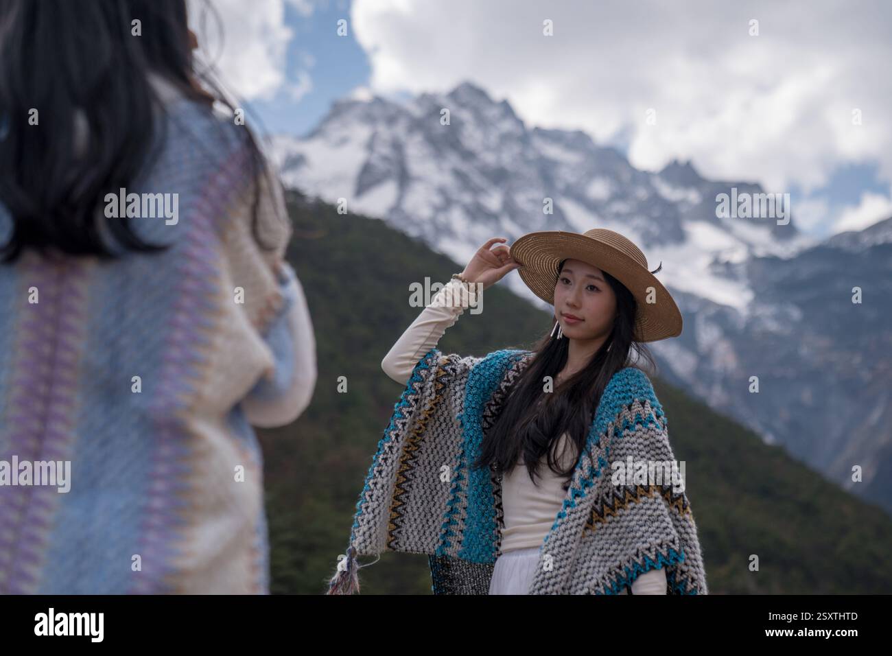 Lijiang. 25th Feb, 2025. A tourist poses for photos at Yulong Snow ...
