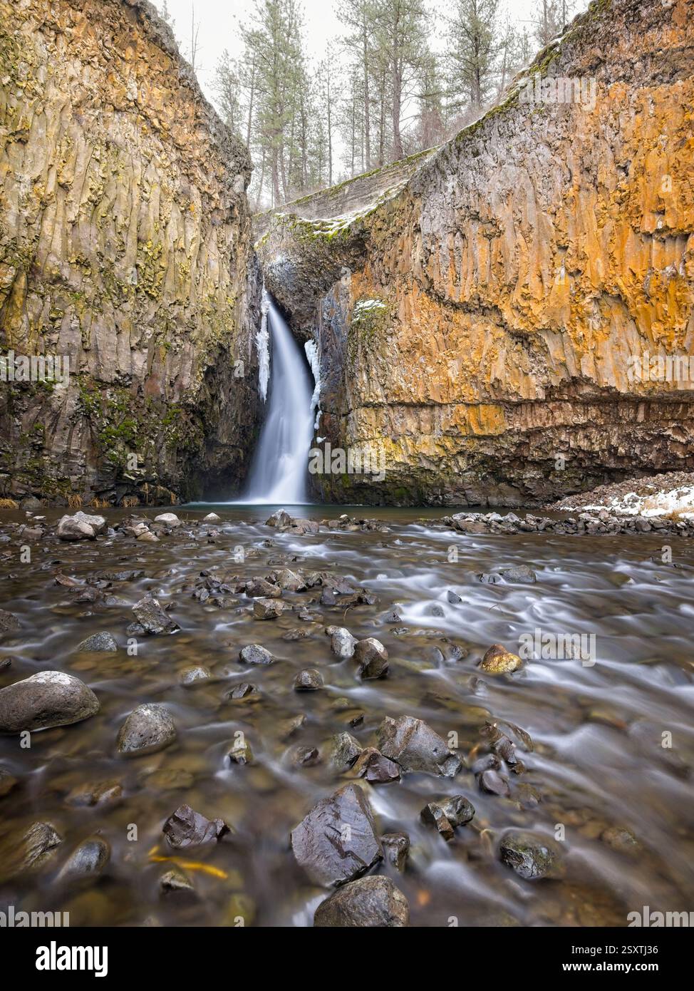 The swift flowing water of Hawk Creek Falls during winter near the ...