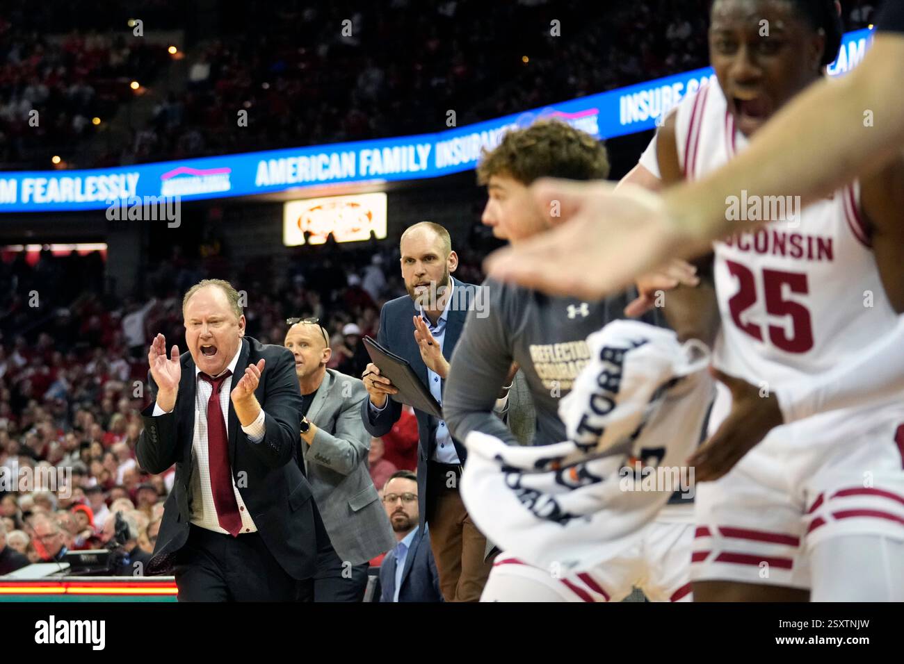 Wisconsin head coach Greg Gard, left, and members of the Wisconsin team ...