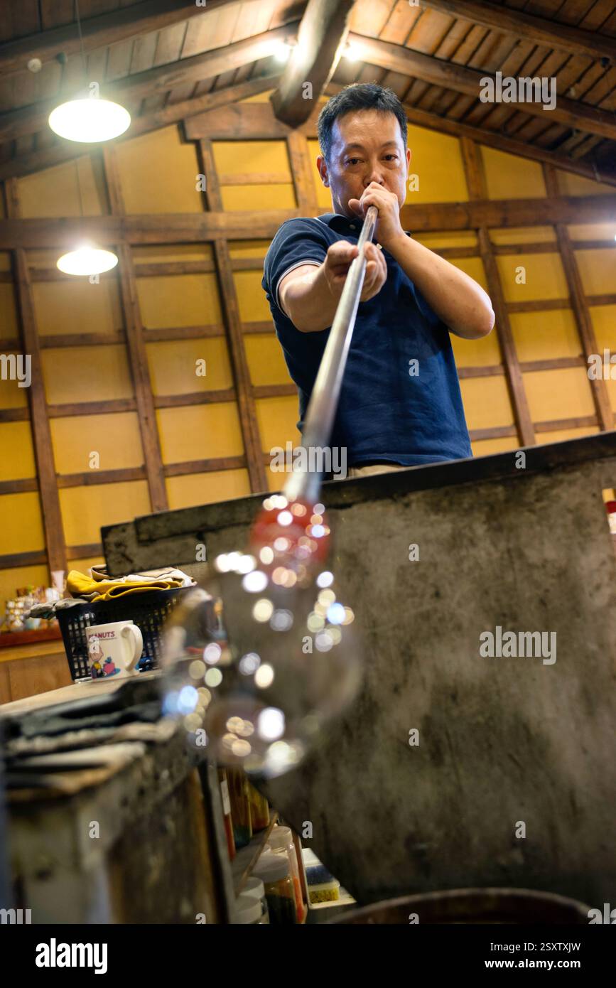 Glass artisan Taizo Yasuda works at his atelier in the historical port district of Iwasehama in ...