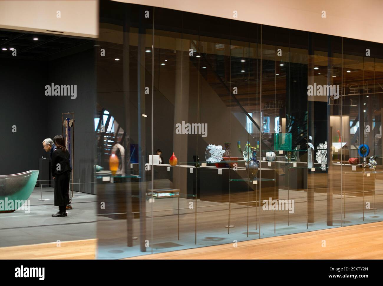 Visitors admire some of the glass art works on display inside the ...