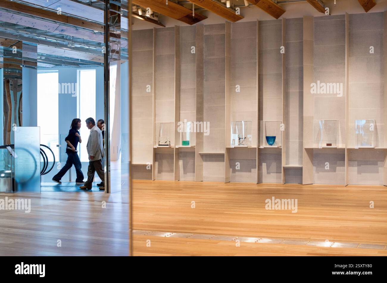 Visitors walk past some of the glass art works on display inside the ...