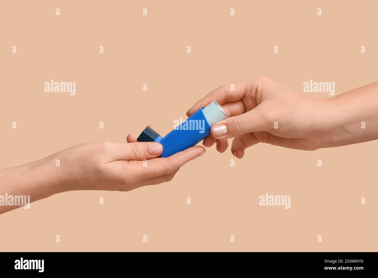 Female hands with modern asthma inhaler on beige background Stock Photo ...