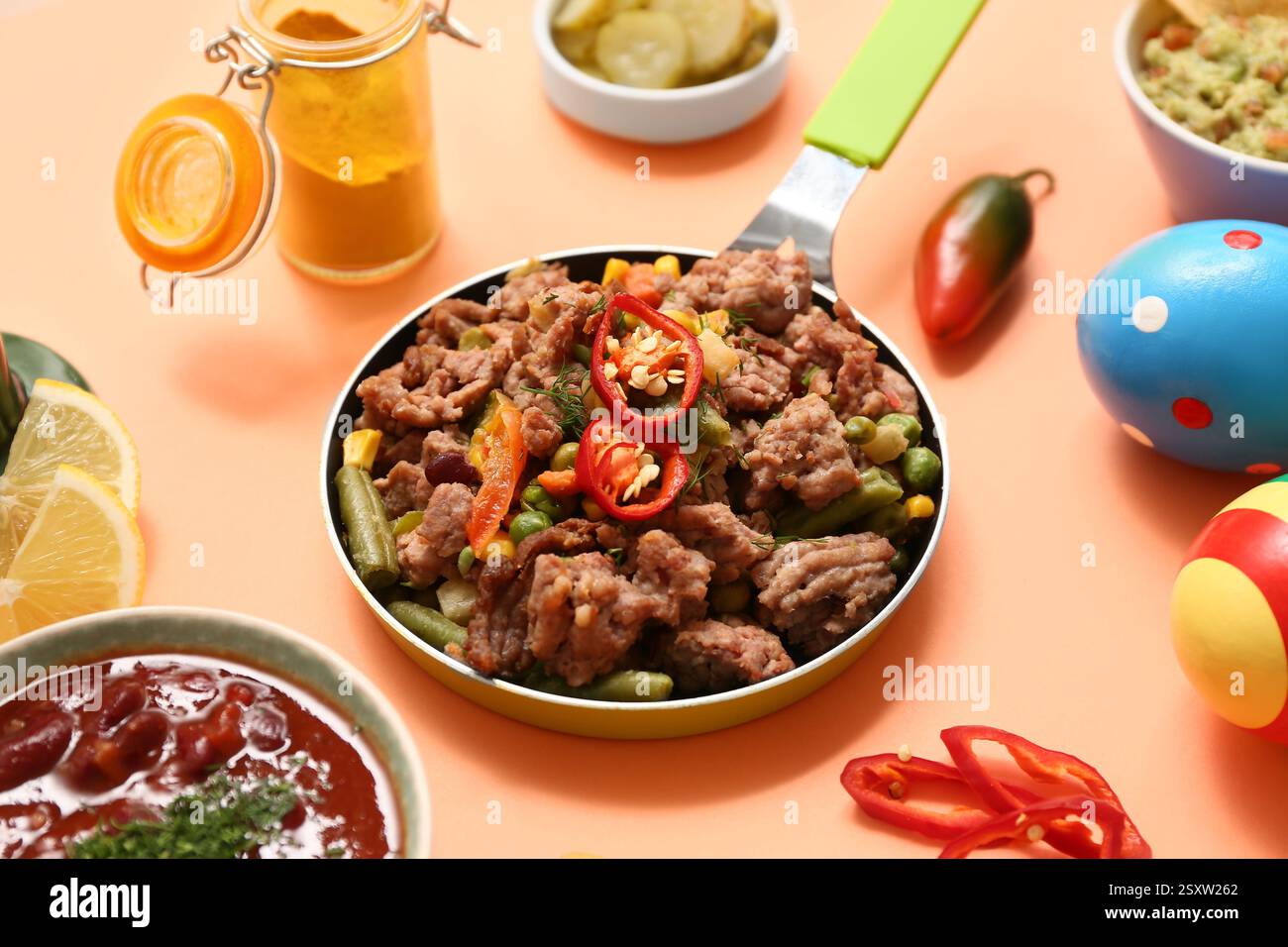 Frying pan with traditional Mexican burrito filling on beige background ...