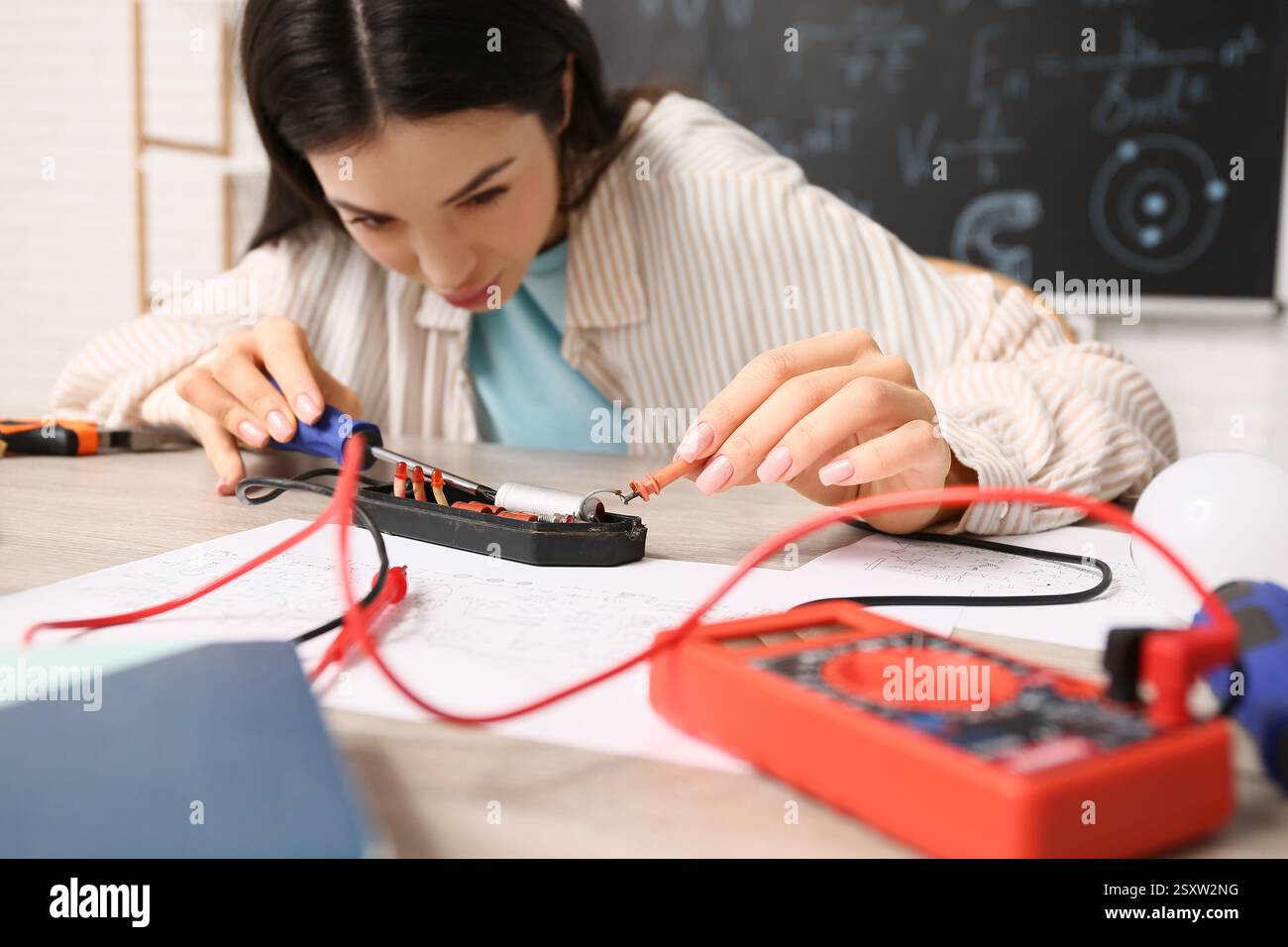 Female inventor making device at table in workshop Stock Photo - Alamy