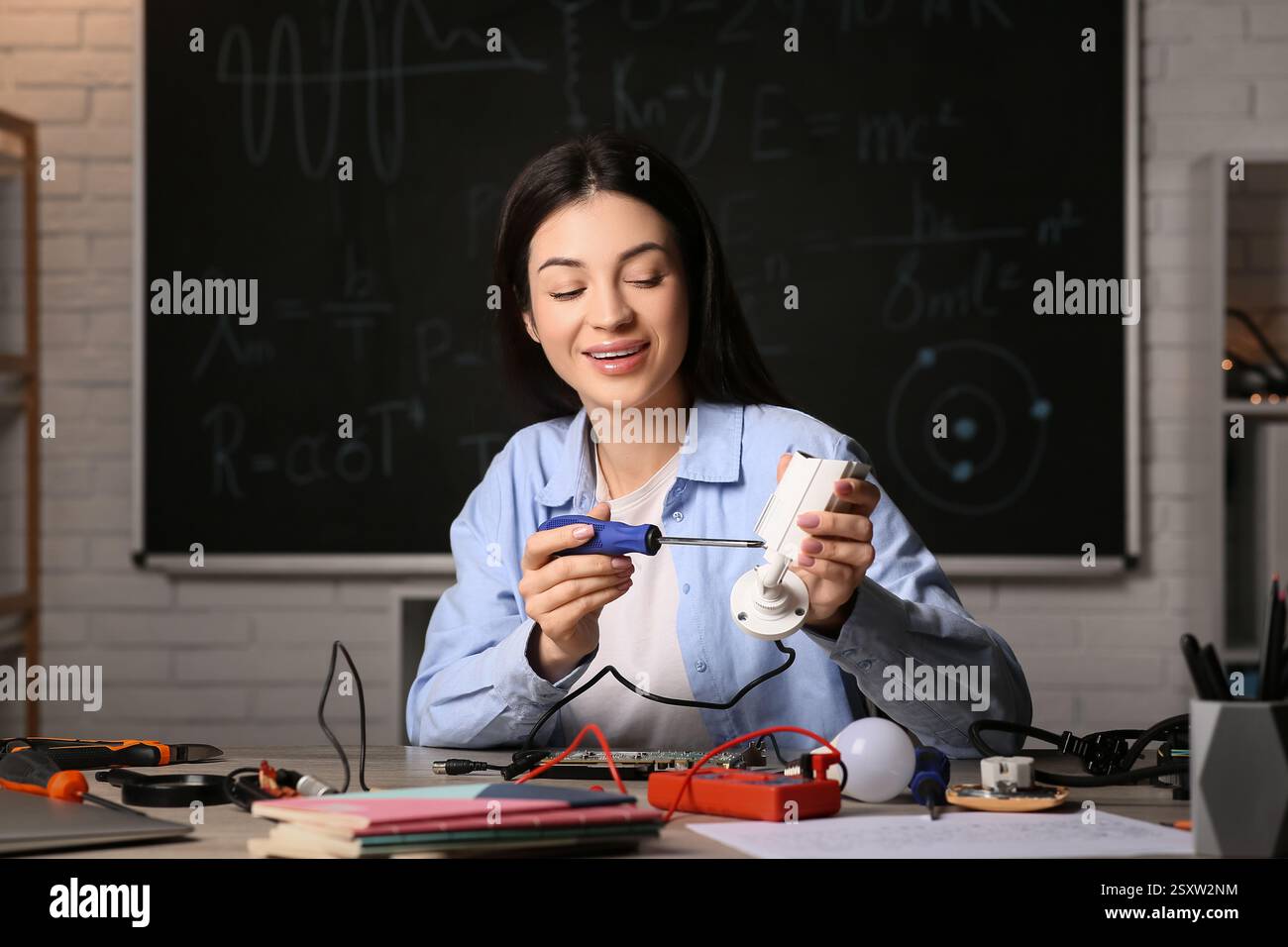 Female inventor making device at table in workshop Stock Photo - Alamy