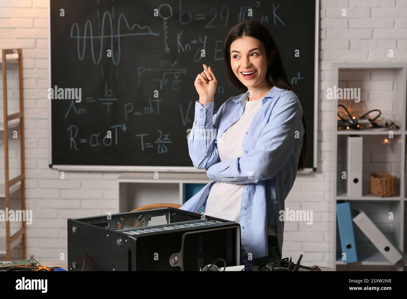 Female inventor pointing at something in workshop Stock Photo - Alamy