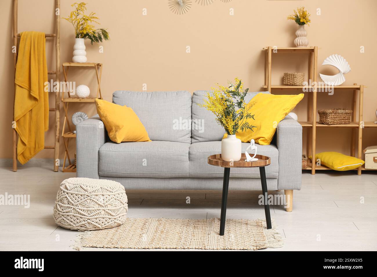 Interior of living room with sofa, shelves and mimosa flowers in vases ...