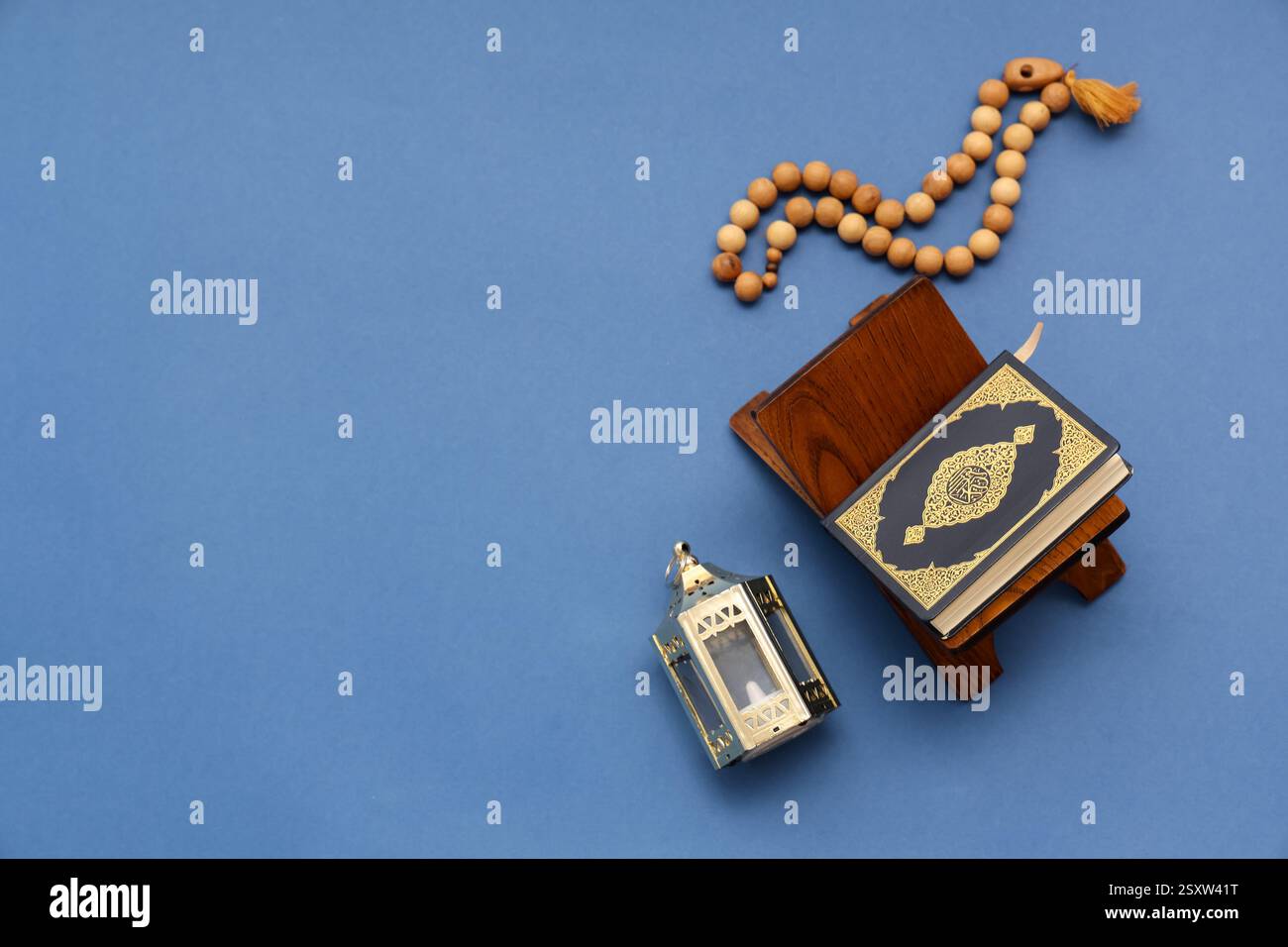 Rehal with Koran, fanoos and prayer beads on blue background. Ramadan ...