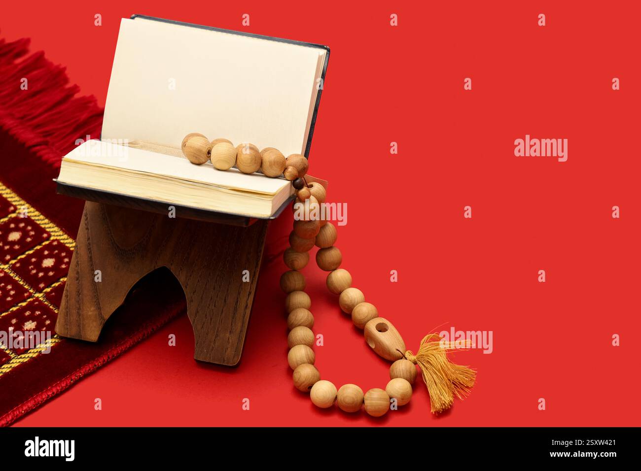 Rehal with Koran and prayer beads on red background. Ramadan ...