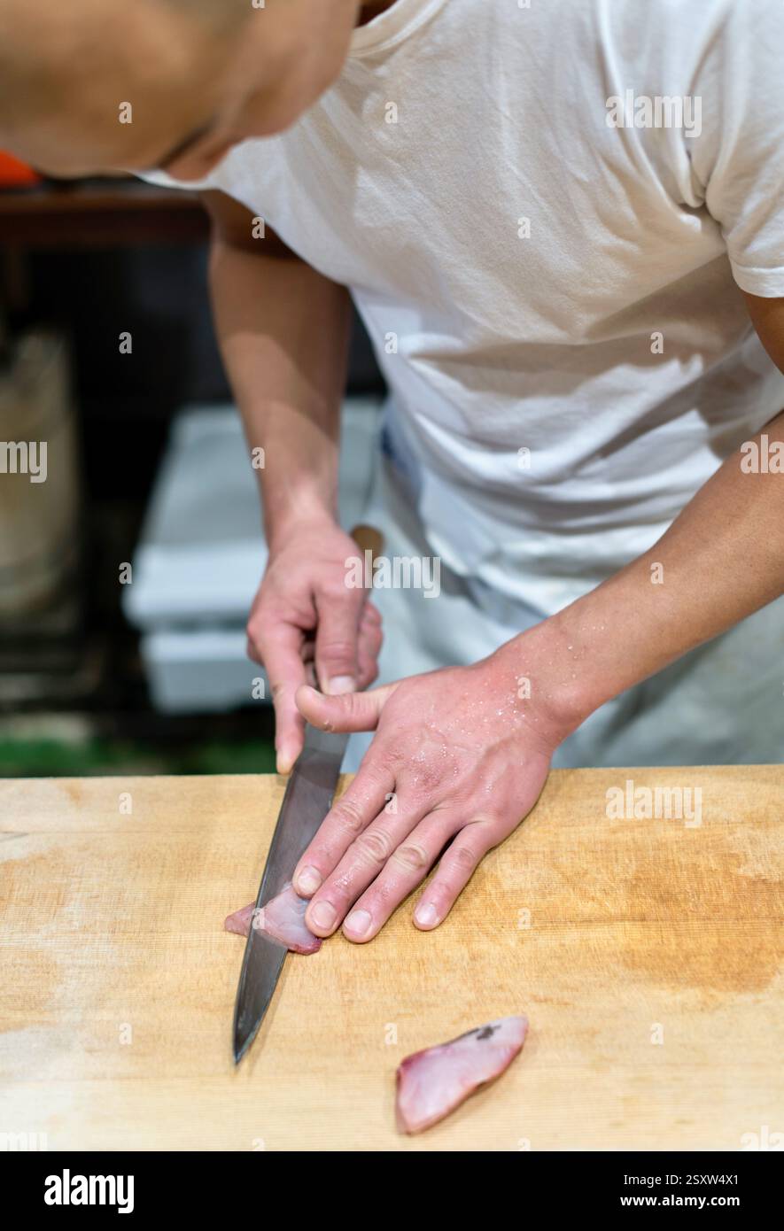 Chef Yasuhiro Aoki cuts slithers of ara (saw-edged perch) at his ...