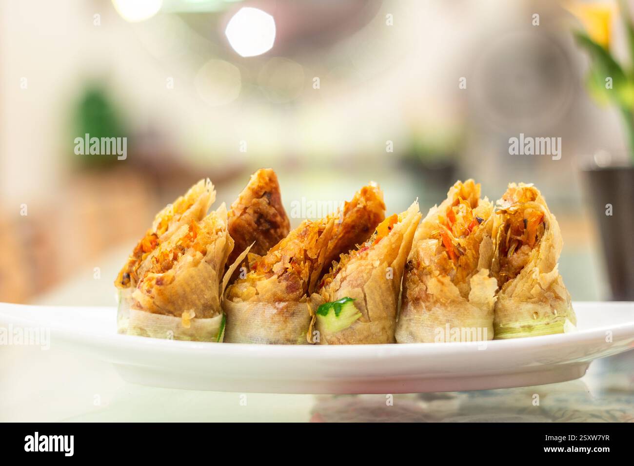Plate of sliced lumpia spring rolls served with dipping sauce at an ...