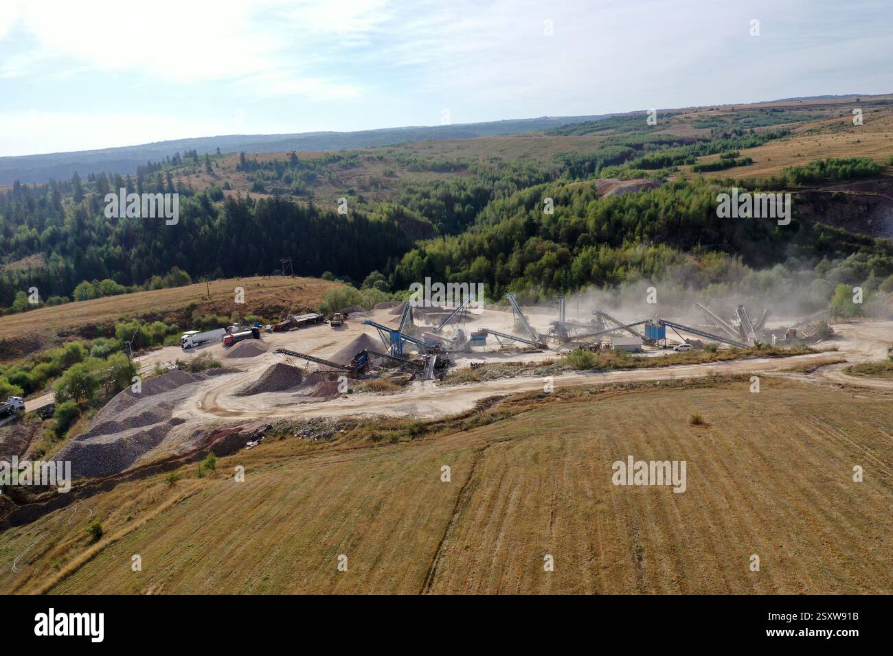 Aerial view of an excavator loading crushed stone into a dump truck in a crushed stone quarry ...