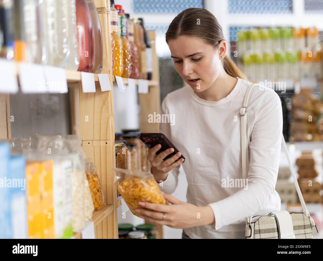Girl scans a QR code to check the expiration date on a package of chips ...