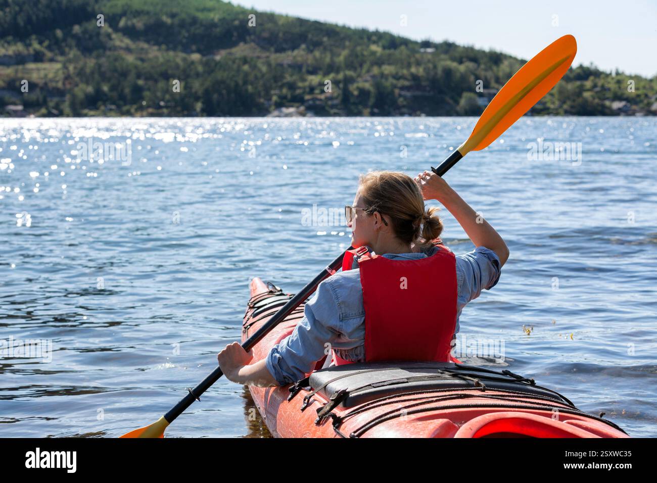 Woman in kayak back view. Happy young woman floating in transparent ...