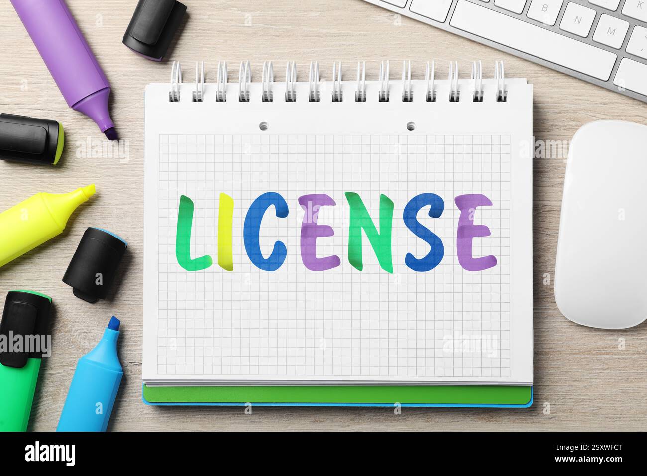 License word written in notebook, markers, computer keyboard and mouse ...