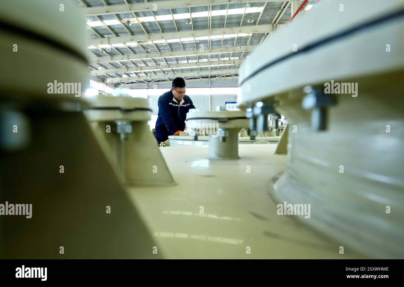 ZHANGYE, CHINA - FEBRUARY 25, 2025 - A staff member is installing ...