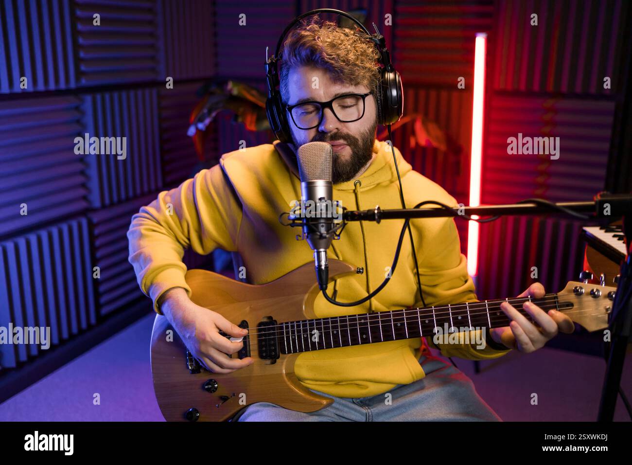 Man vocal artist singing in a recording studio with guitar. Male singer ...