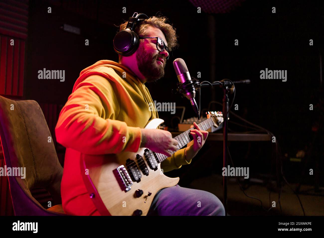 Man vocal artist singing in a recording studio with guitar. Male singer ...