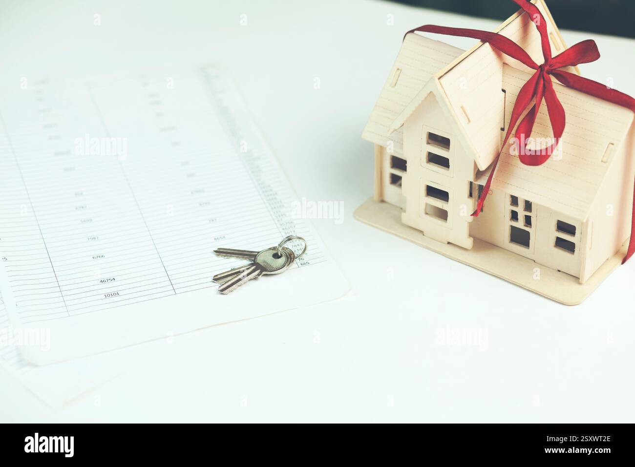 Keys and a pen lying on documents alongside a model of a house Stock ...