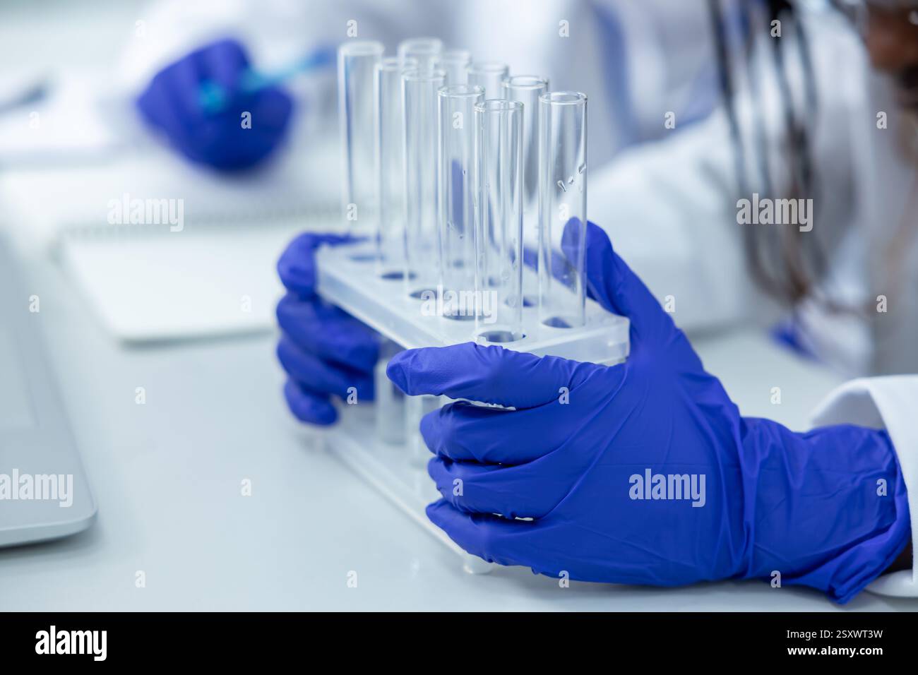 Unrecognizable medical woman in lab holding pipettes conducting test on ...