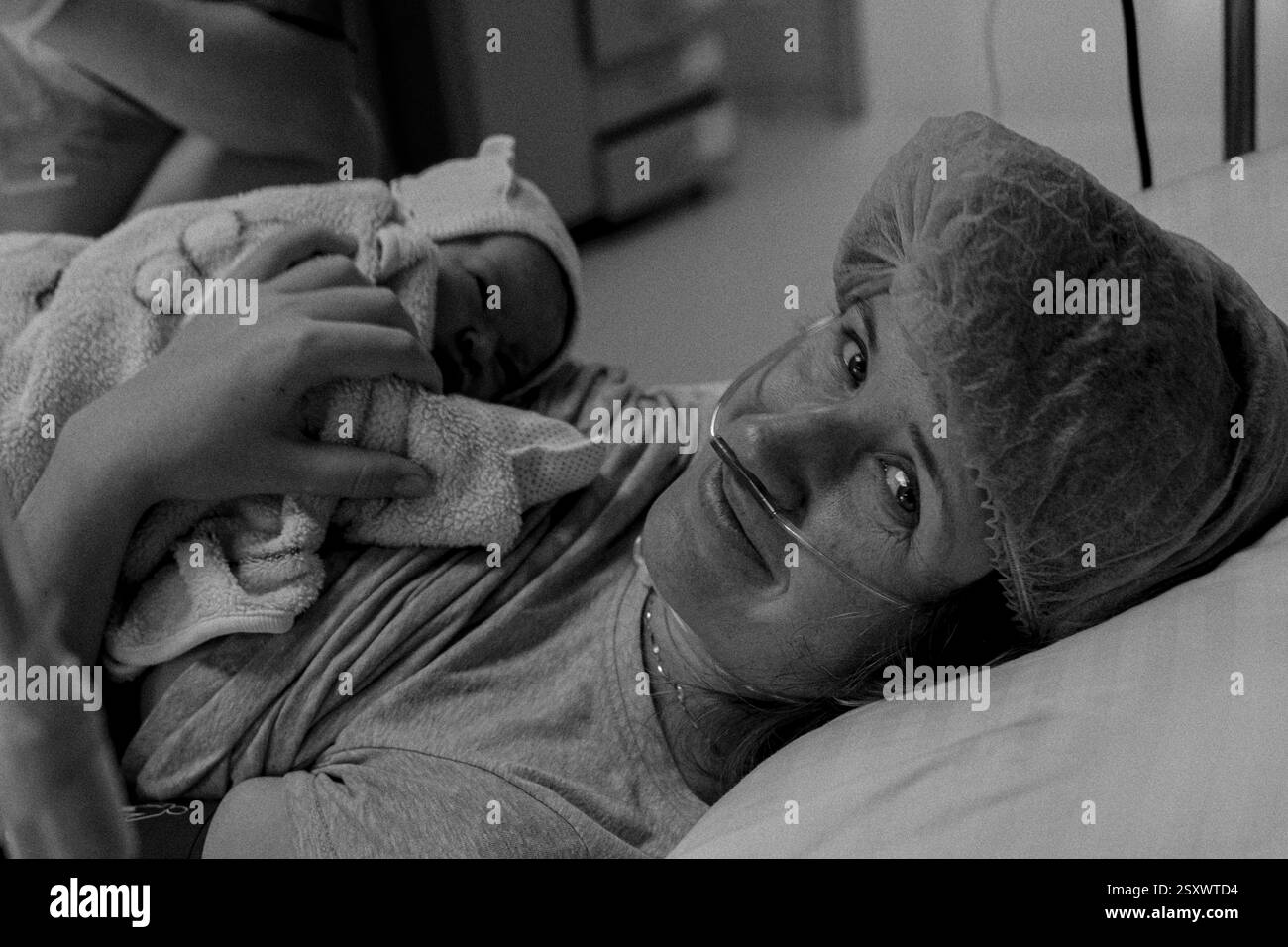 A touching moment of childbirth in a hospital. Doctors and staff assist ...