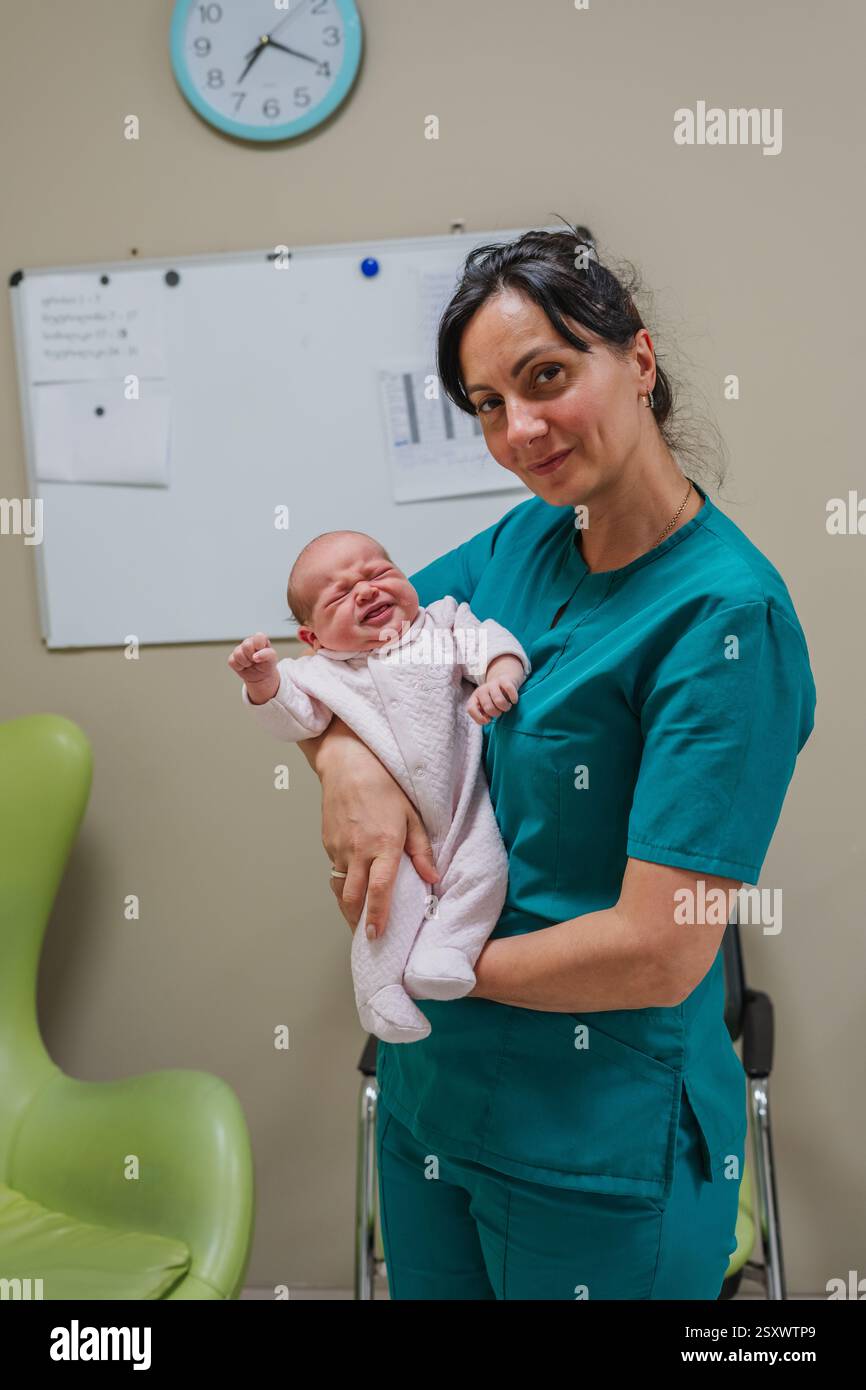 A touching moment of childbirth in a hospital. Doctors and staff assist the mother while the ...