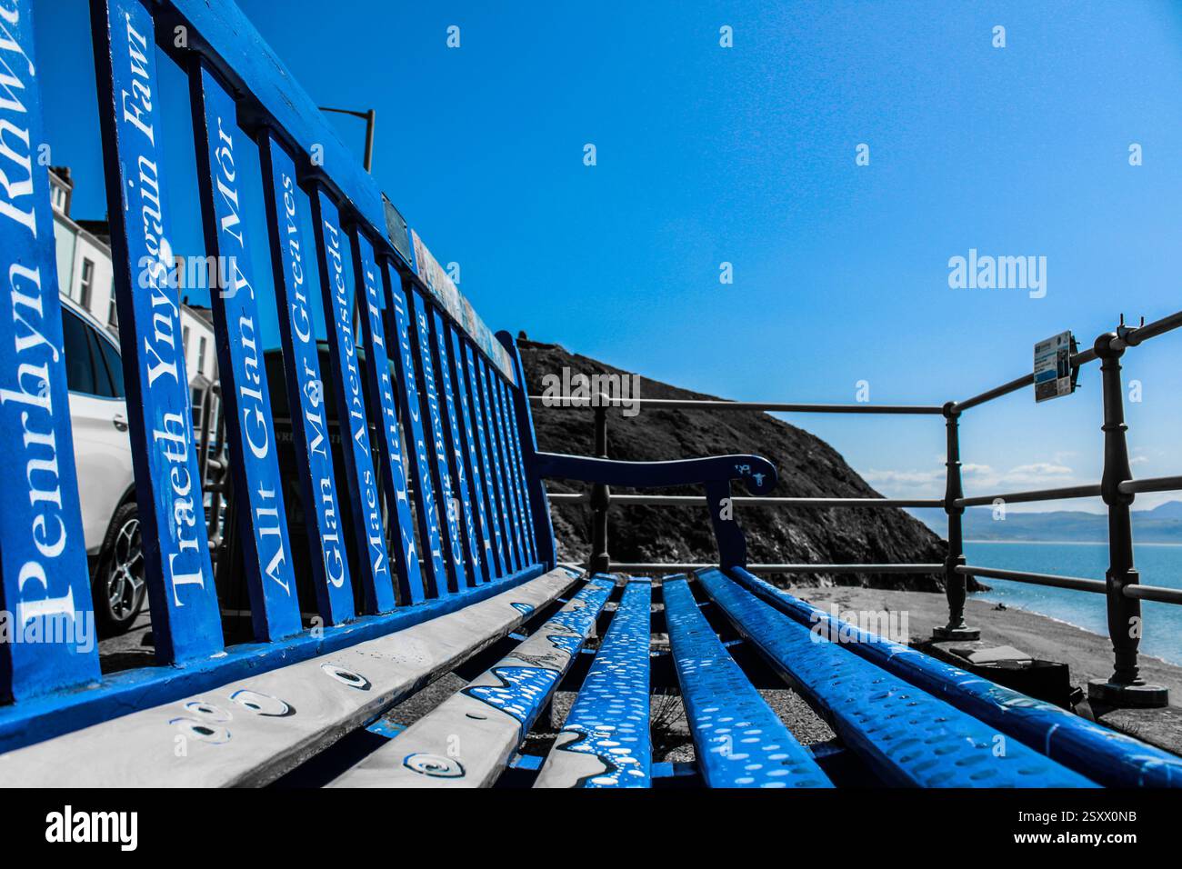 Seaside bench seat at Creccieth in North wales, shown in a blue ...