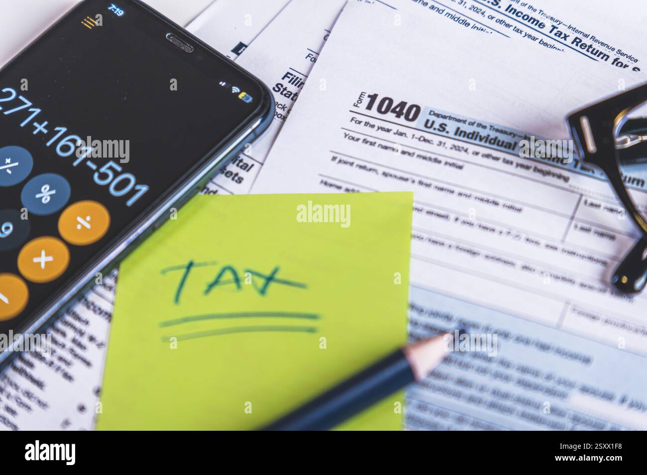 Tax form 1040, w-9, pencil, marker pen, reading glasses and laptop are ...