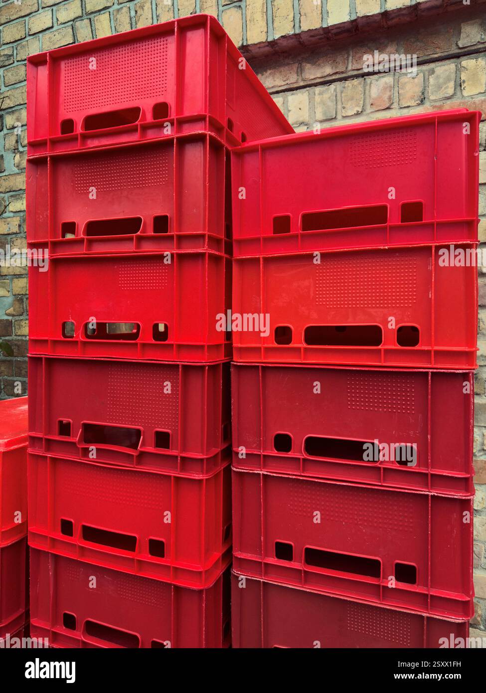 Red bins stacked upside down outdoors Stock Photo - Alamy