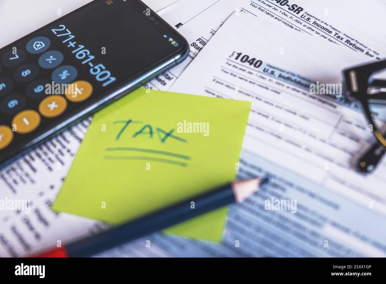 Tax form 1040, w-9, pencil, marker pen, reading glasses and laptop are ...