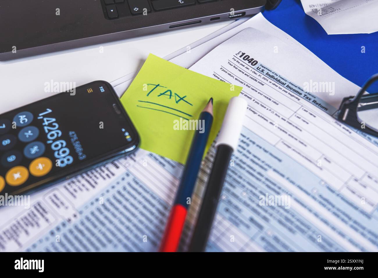 Tax form 1040, w-9, pencil, marker pen, reading glasses and laptop are ...