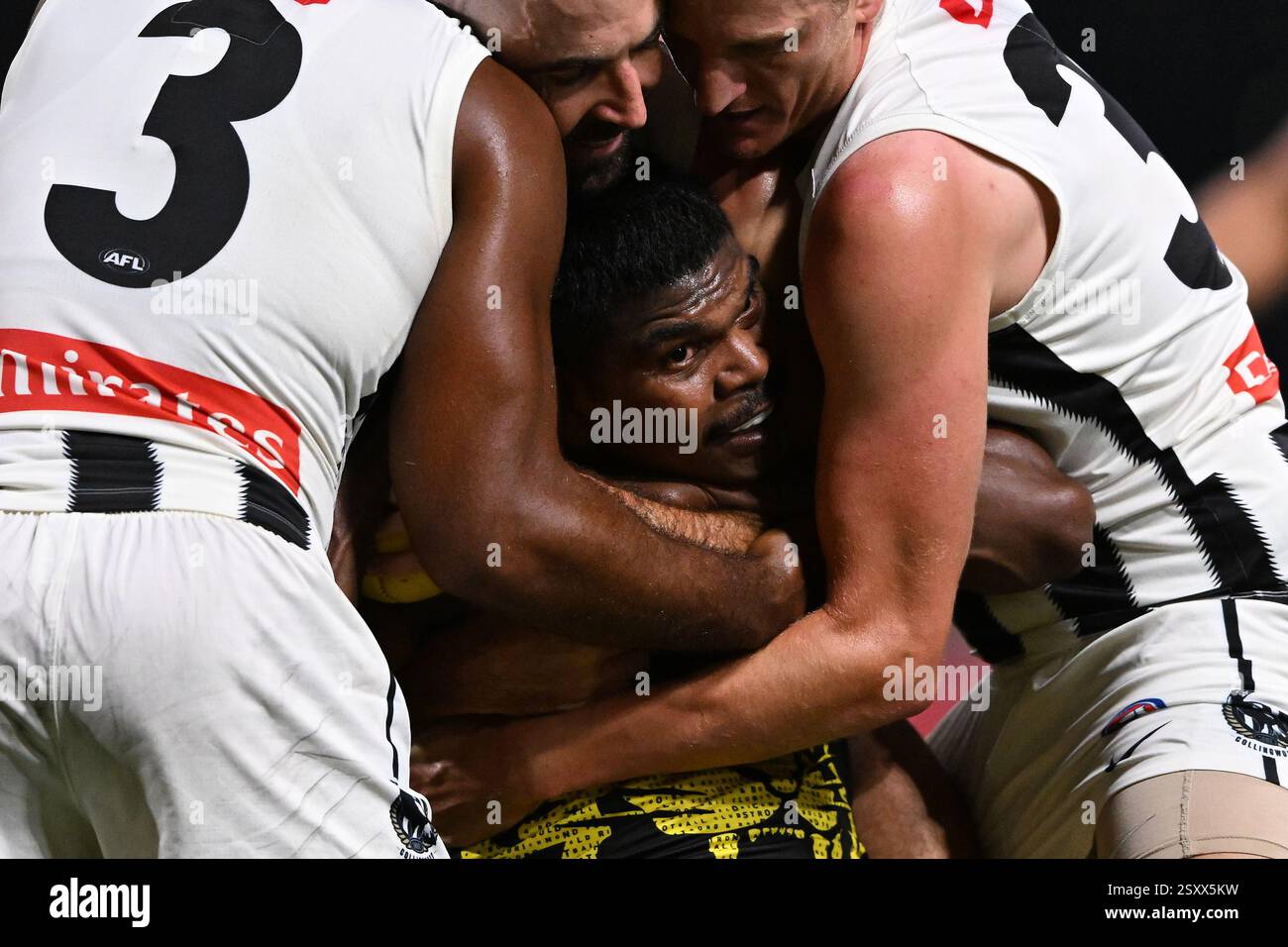 Maurice Rioli of Richmond (centre) is tackled by Steele Sidebottom of ...