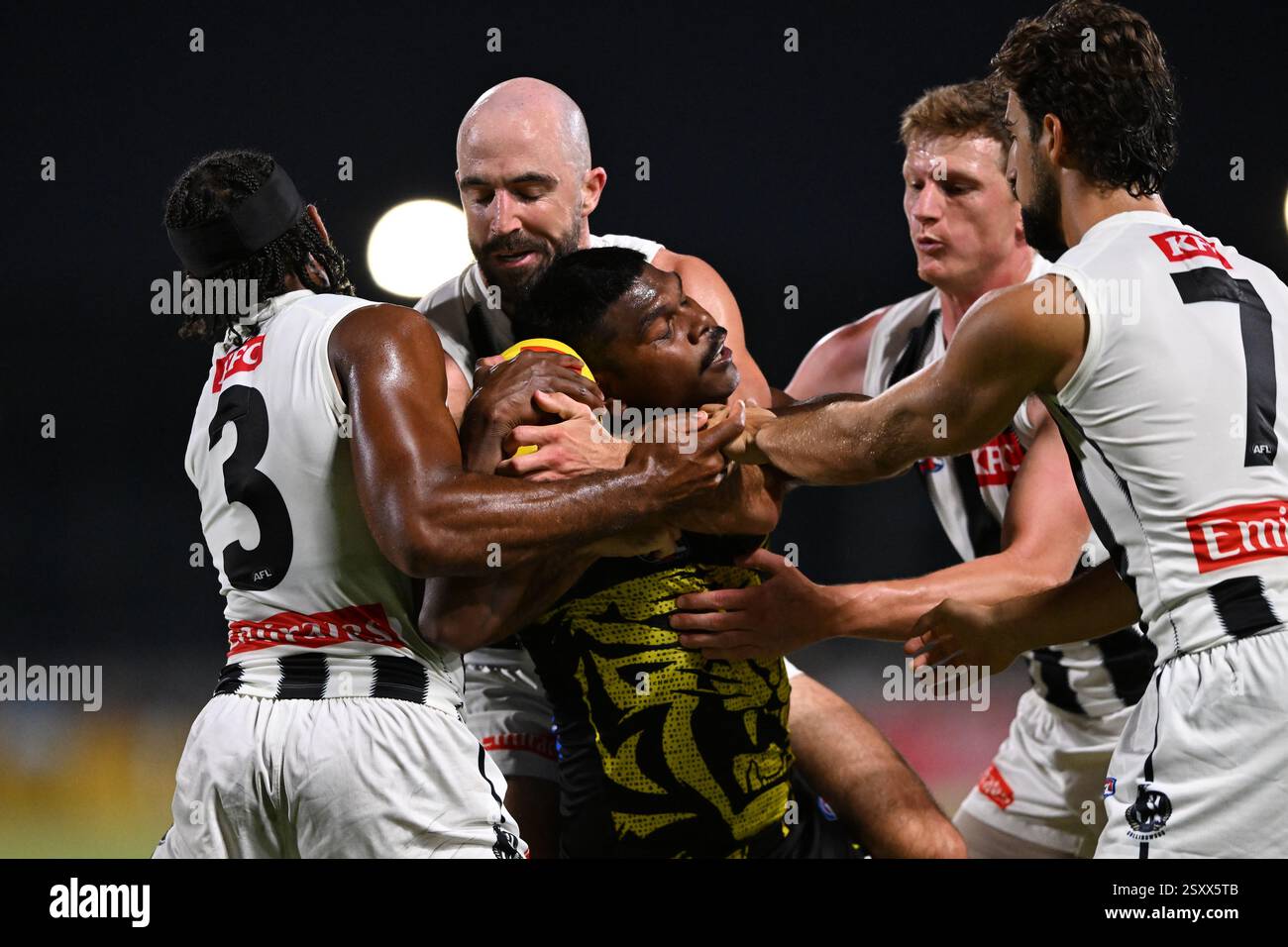 Maurice Rioli of Richmond (centre) is tackled by Steele Sidebottom of ...