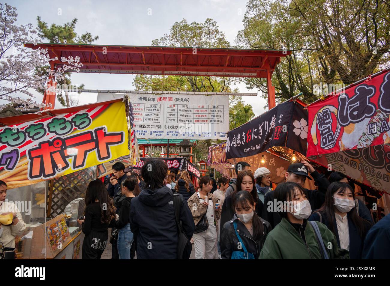 Tourists enjoy Japanese local delicacies in stalls inside the complex ...