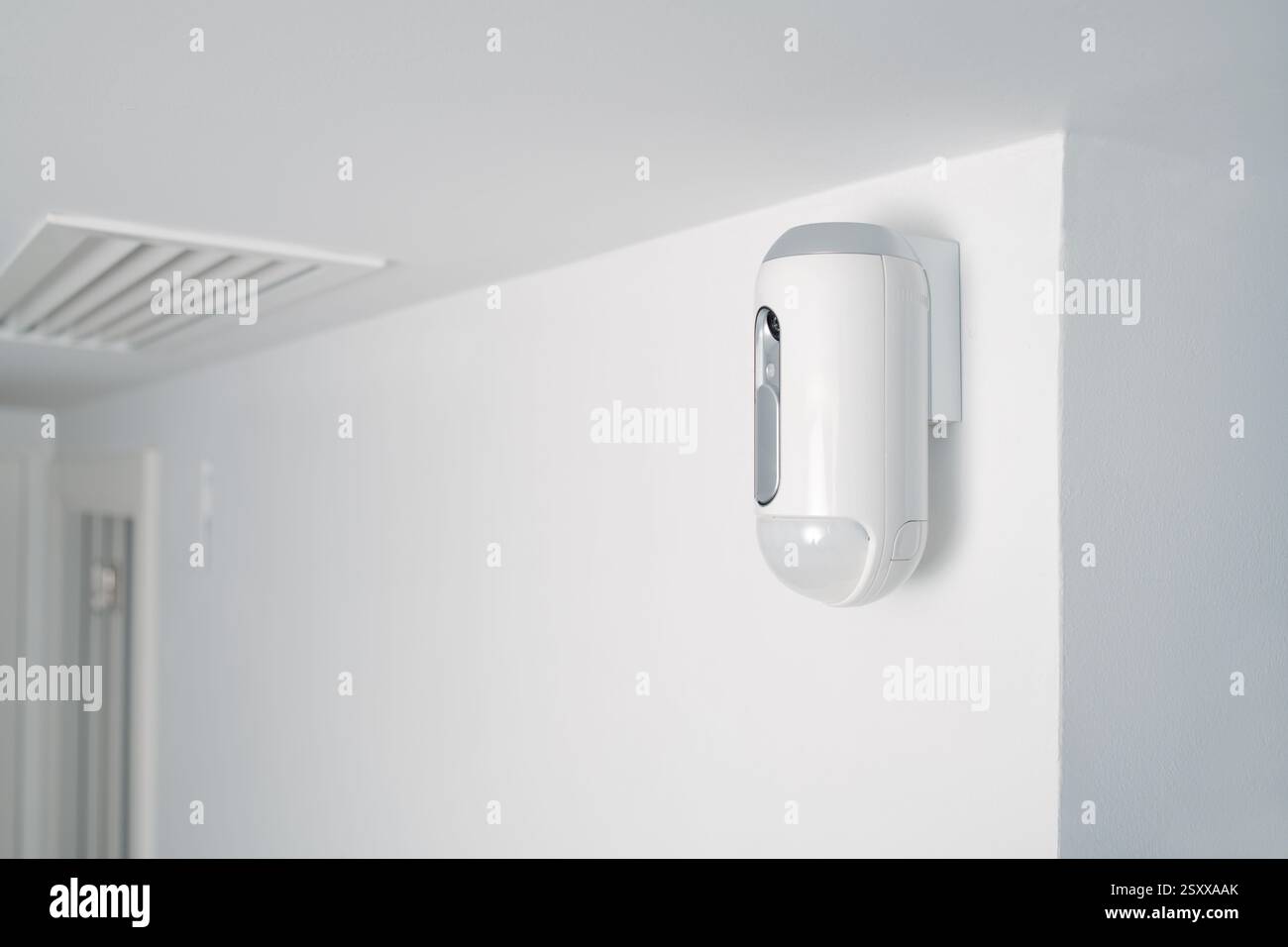 a motion detector equipped with a camera, mounted on a wall, indoors ...