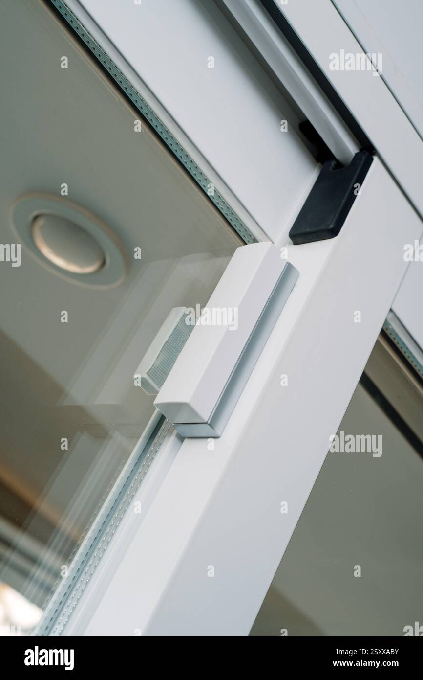 closeup of a window equipped with a wireless glass break detector and ...