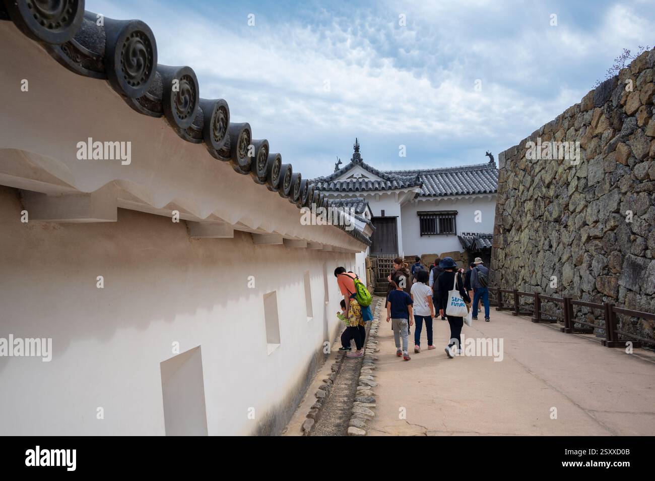 Tourists inside the Himeji Castle, a hilltop Japanese castle complex ...
