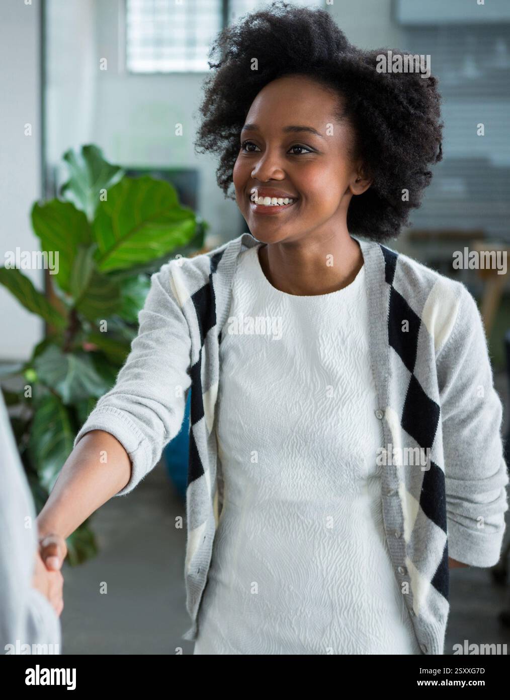Smiling woman in office shaking hands, making positive first impression ...