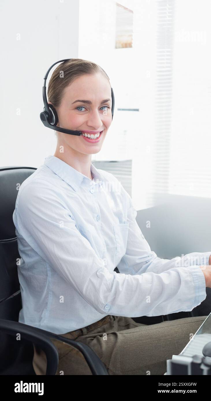 Assisting customers at office desk, woman smiling with headset on Stock ...