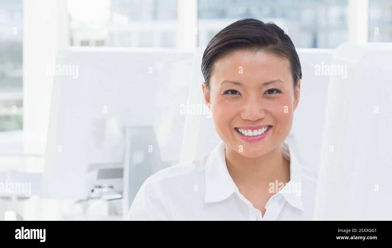 Smiling work team using computer in office Stock Photo - Alamy