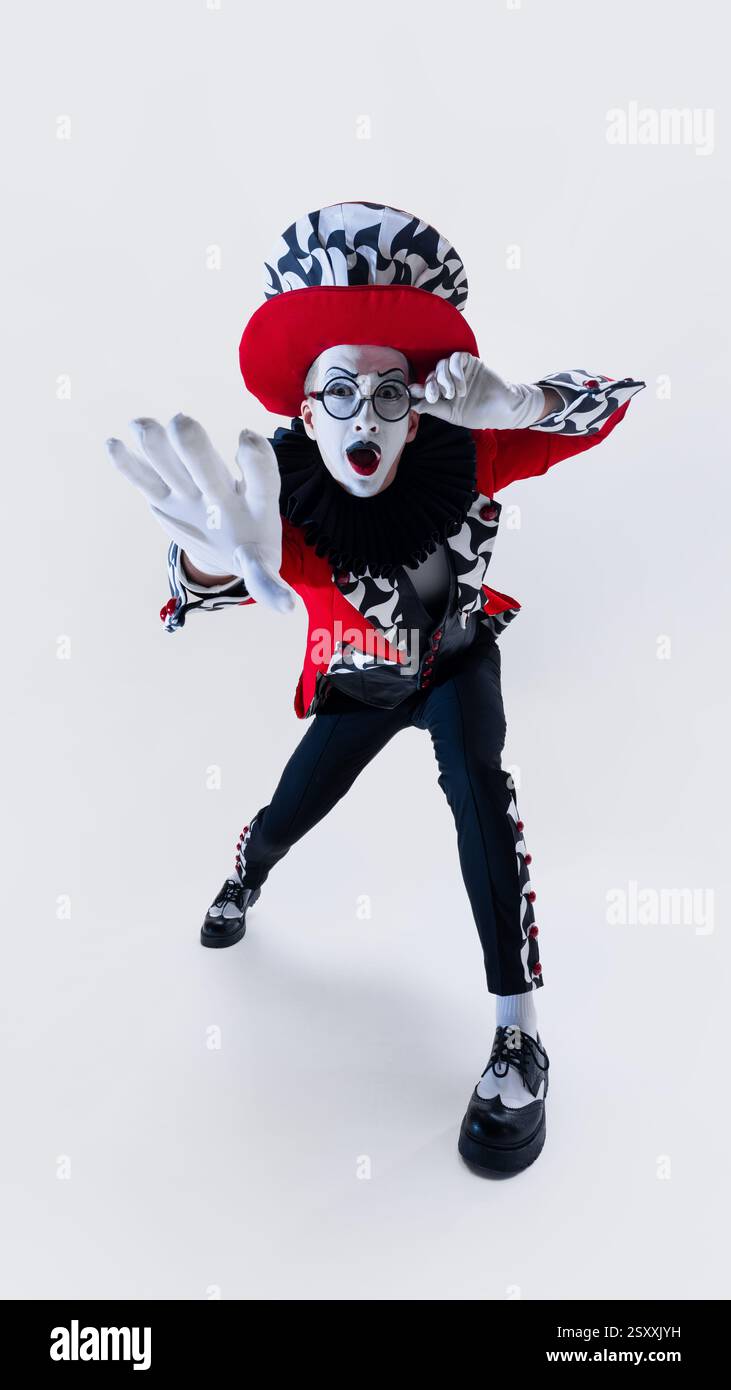 Playful mime artist reaching out with gloved hands, face full of ...
