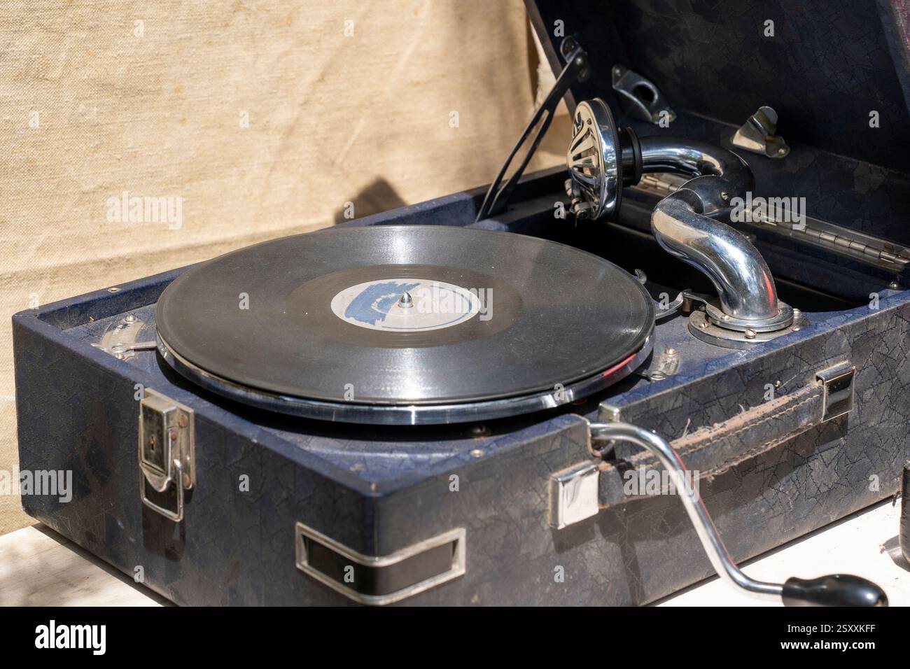A classic portable gramophone with a black vinyl record is displayed on ...