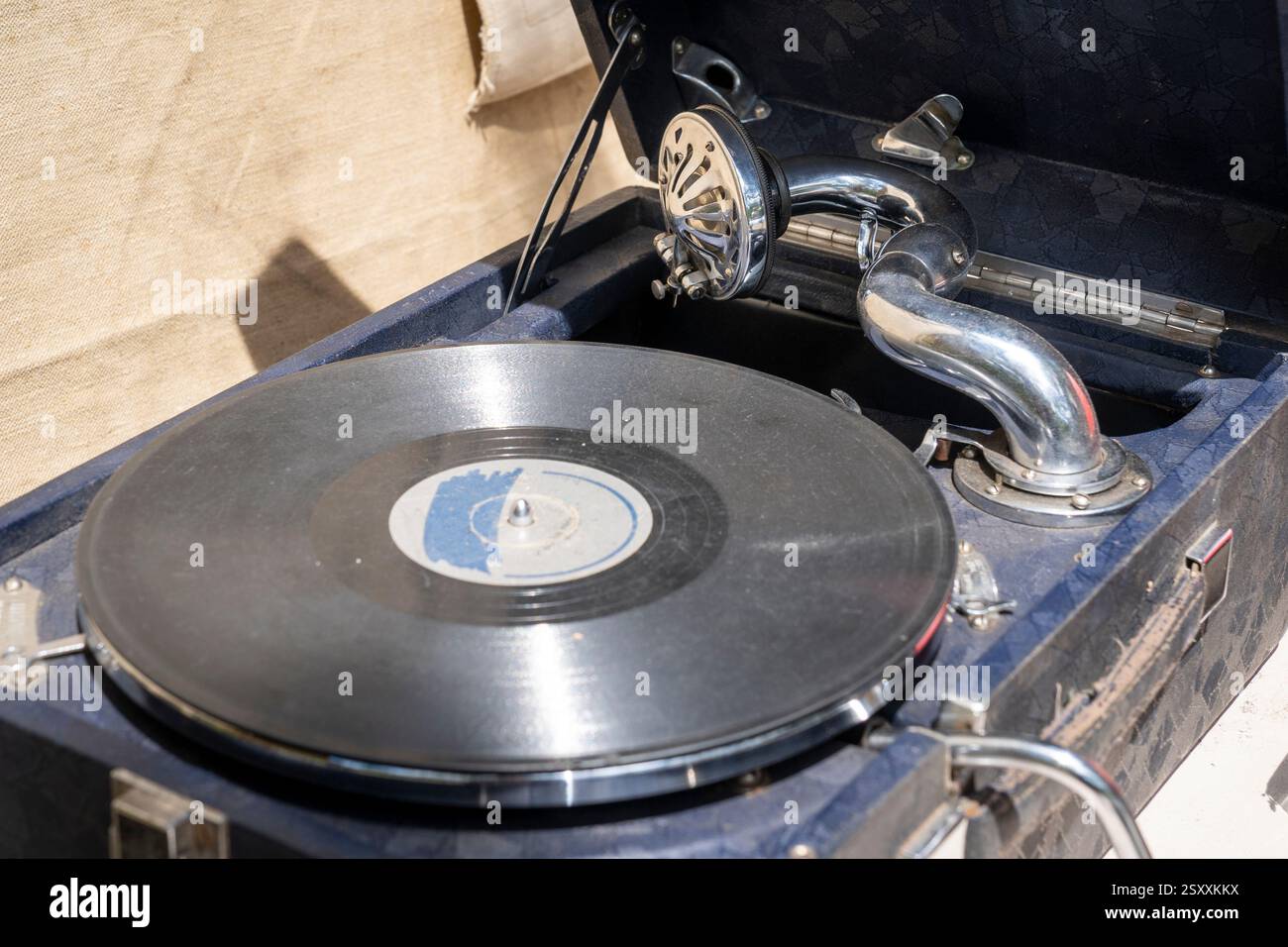 A classic portable gramophone with a black vinyl record is displayed on ...