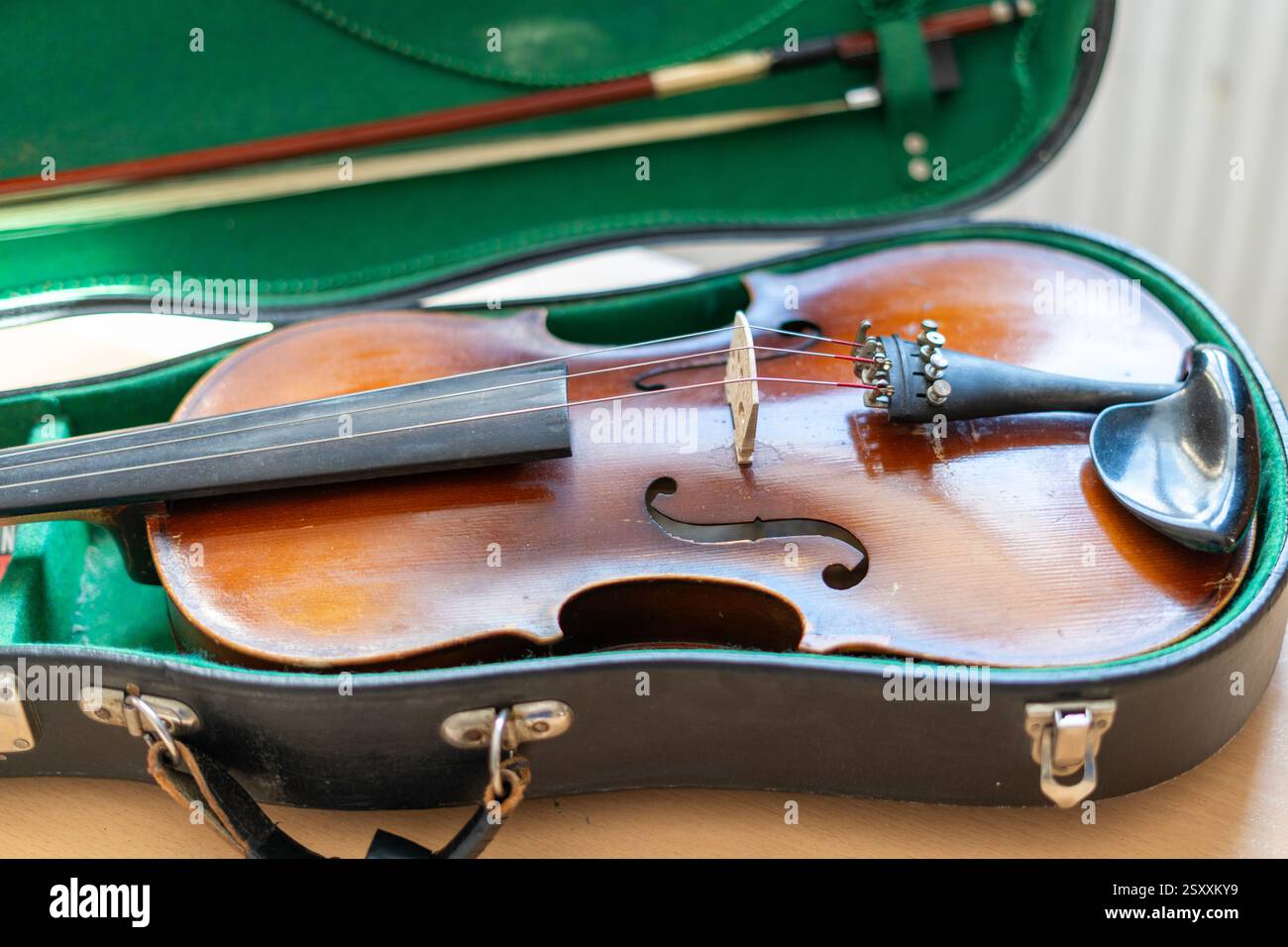 An old violin with a rich wooden patina rests inside its open, worn ...