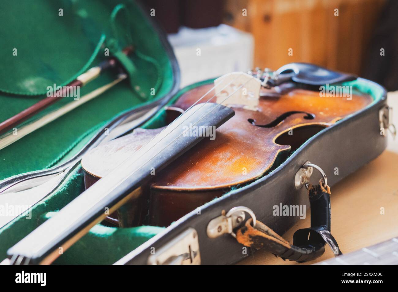 An old violin with a rich wooden patina rests inside its open, worn ...