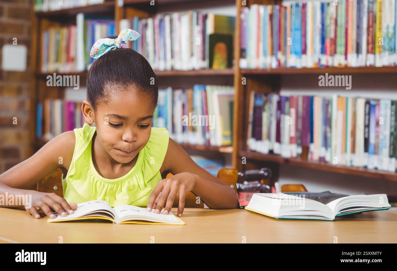 Young girl reading book in school library, concentrating on story, copy ...