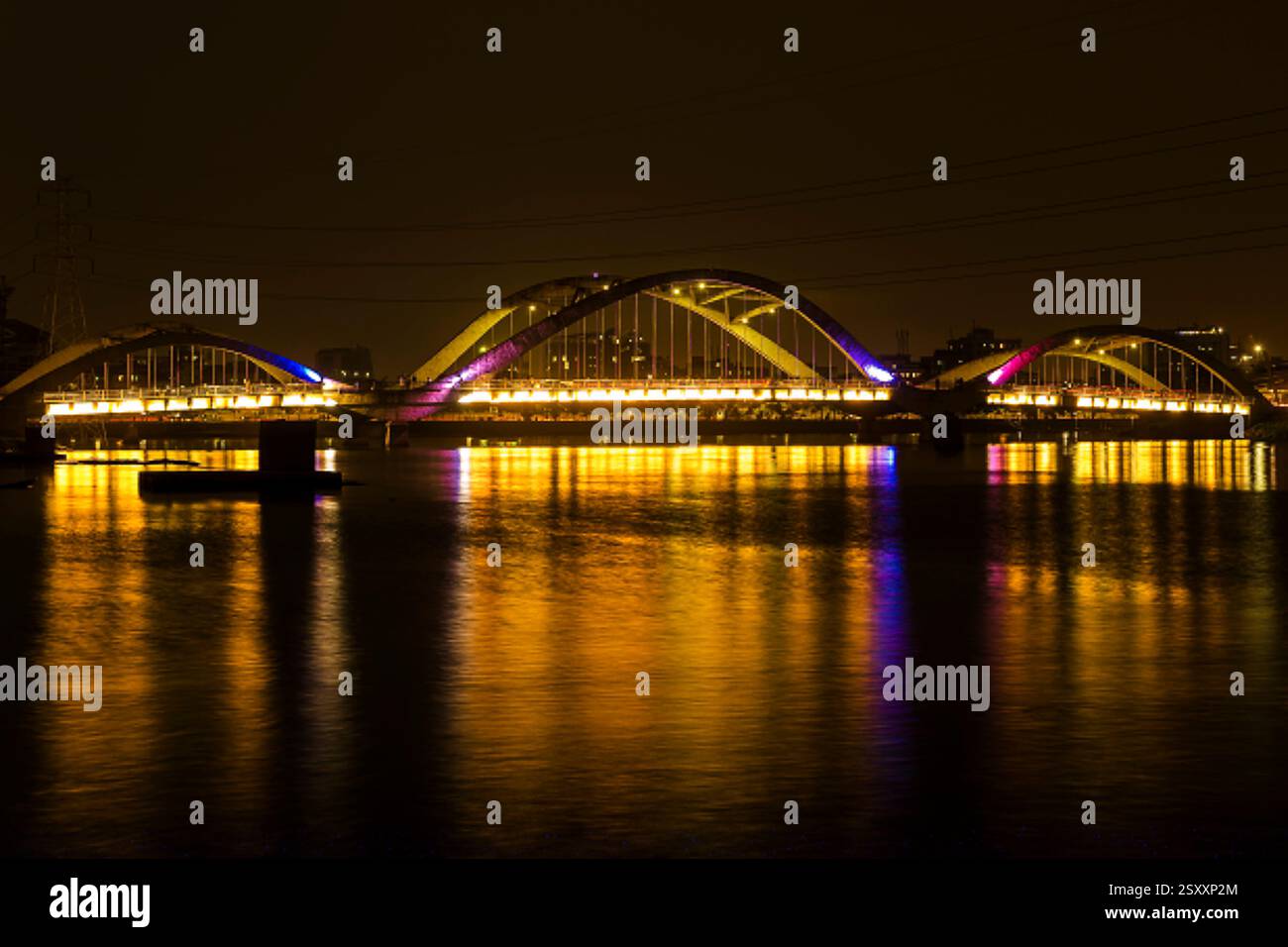 Stunning Bridge at Night with Vibrant Reflections on Water Stock Photo ...